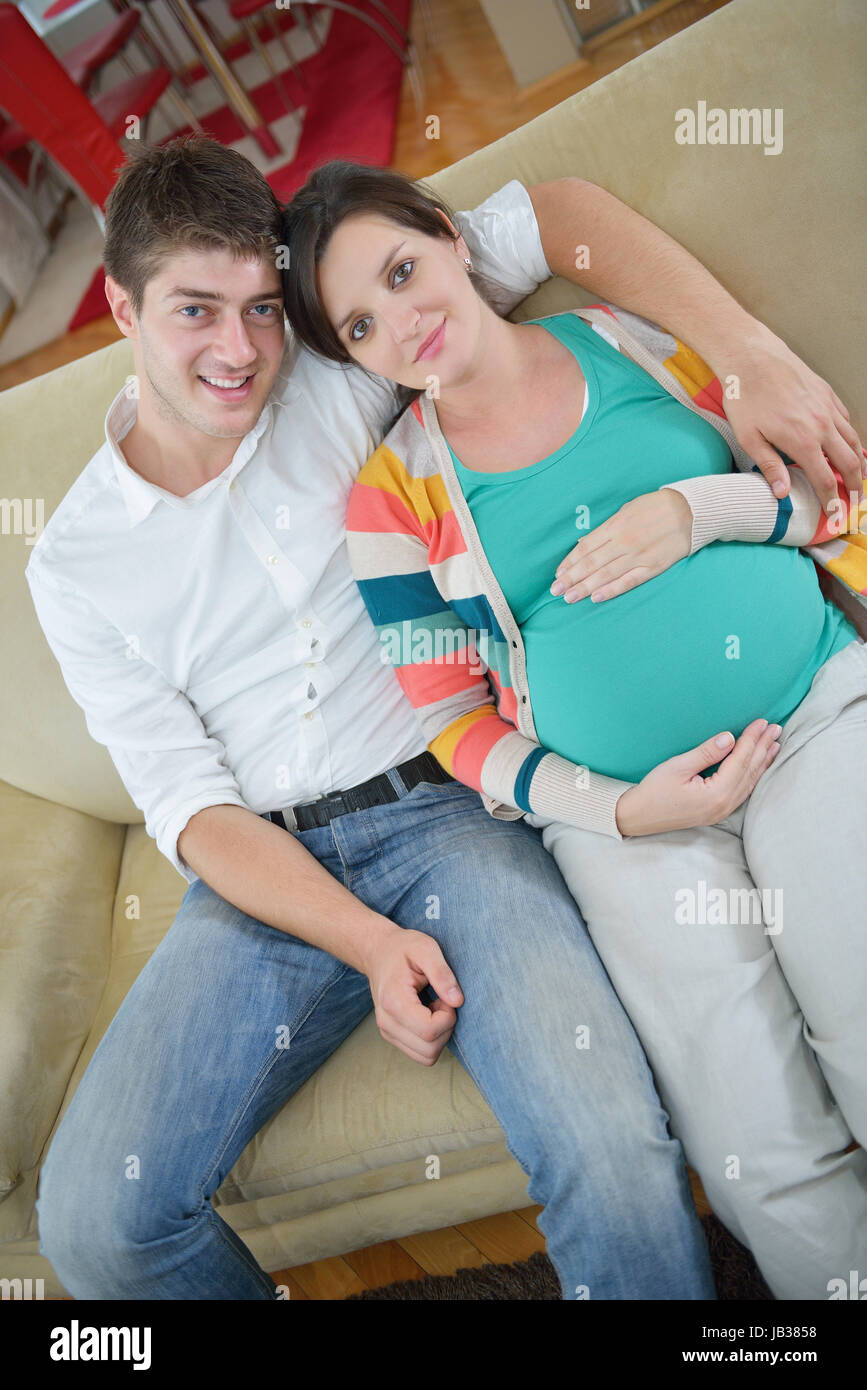 pregnant woman with her husband have fun relax and using tablet comture ...