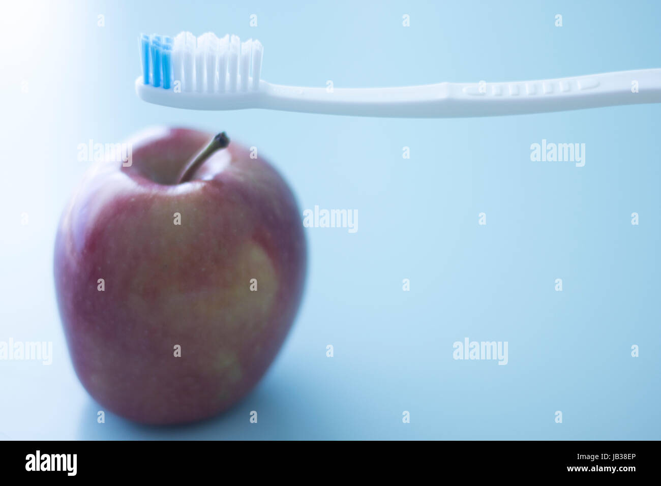 Dental toothbrush to clean teeth and fresh red apple for healthy eating ...