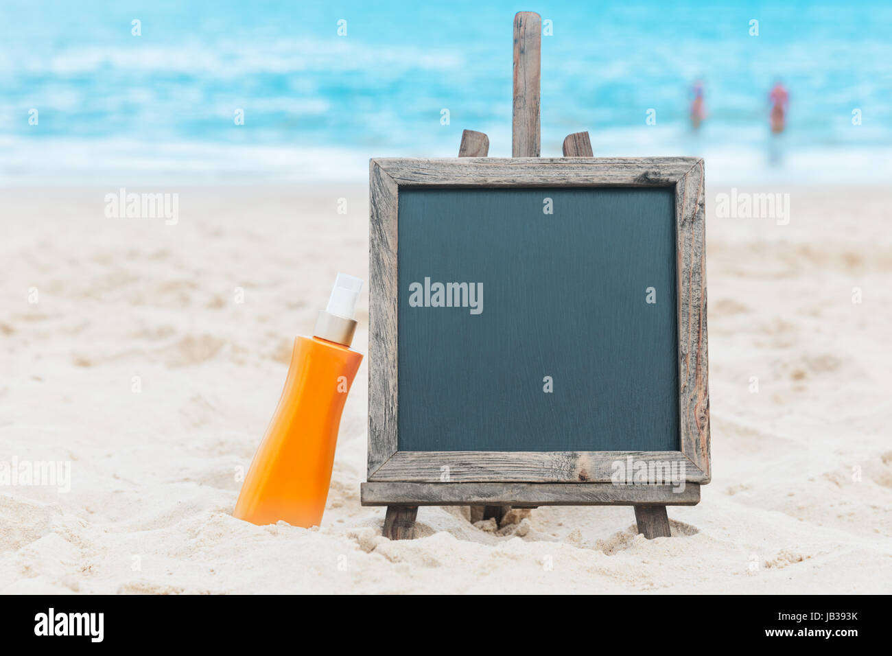 Chalk board with sunscreen cream in the sand on the beach tropic exotic ...
