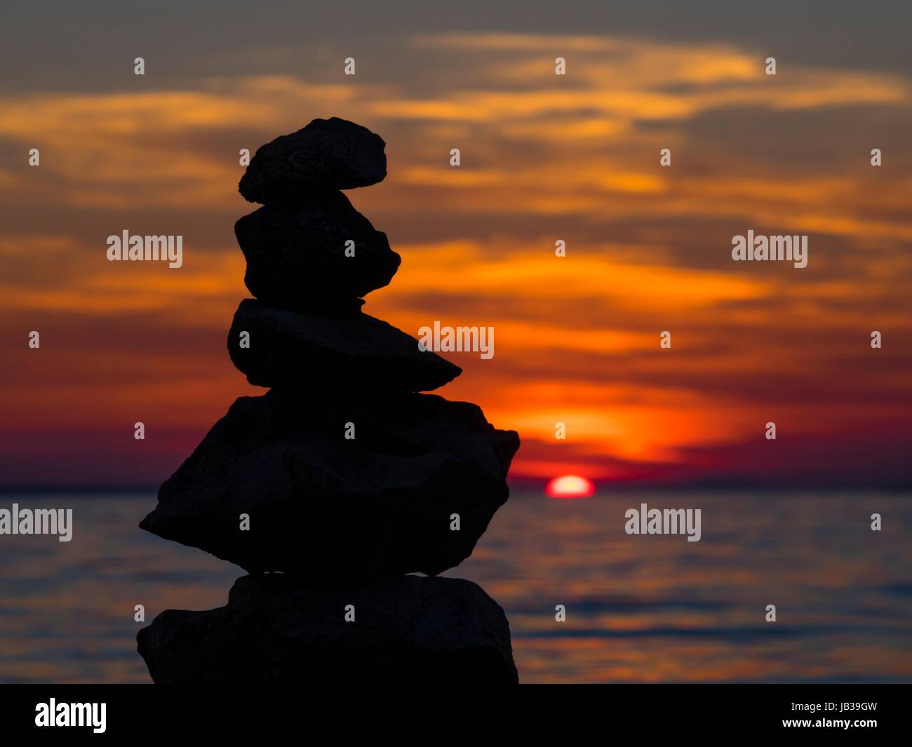 Rocks in silhouette against the setting sun hi-res stock photography ...