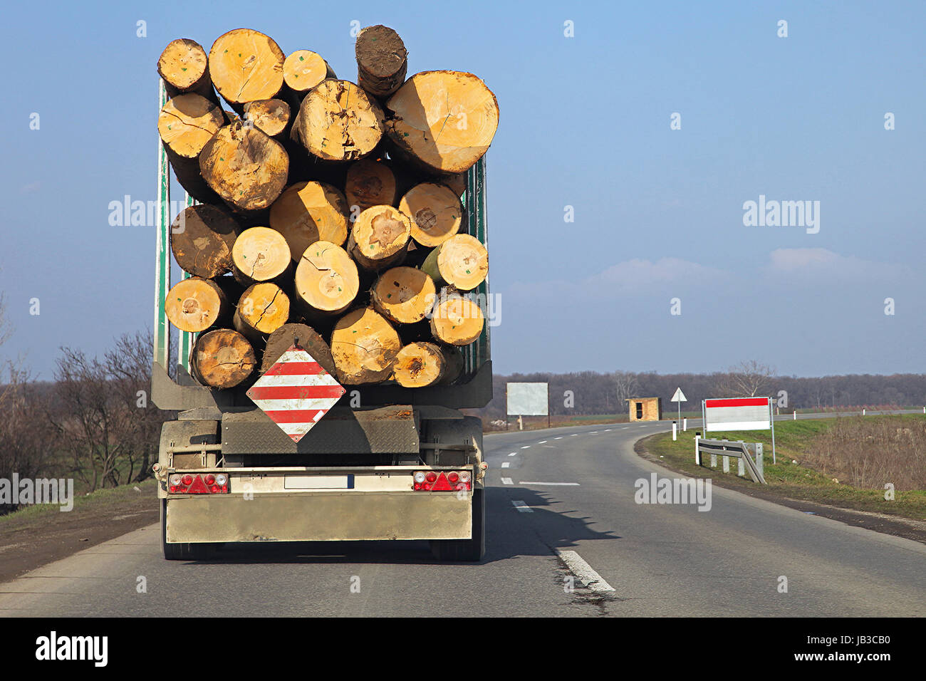 Logging lorry carry wooden logs at road Stock Photo - Alamy