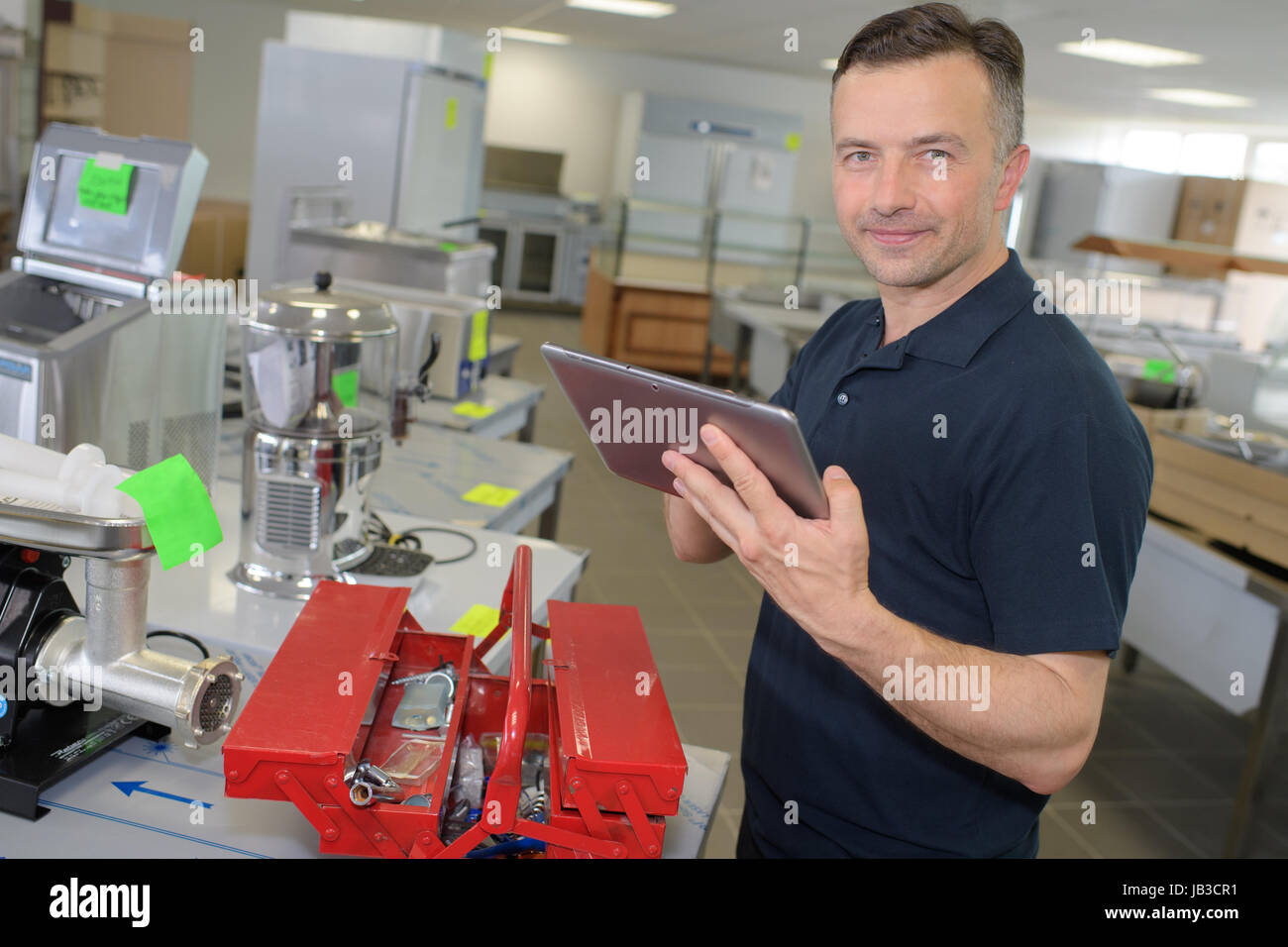 male technician working while holding tablet Stock Photo - Alamy