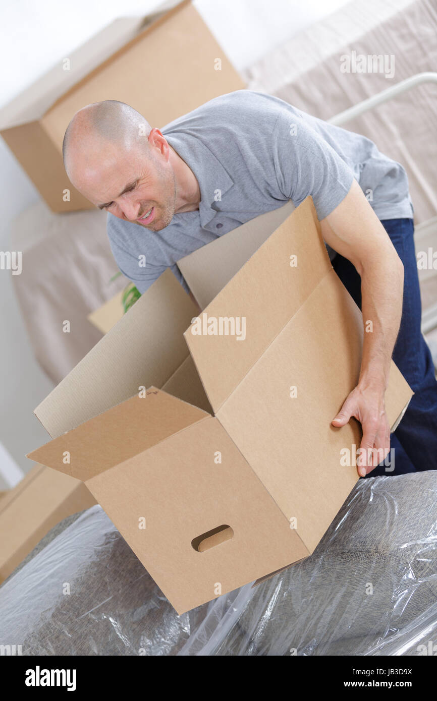 man holding a heavy box Stock Photo - Alamy