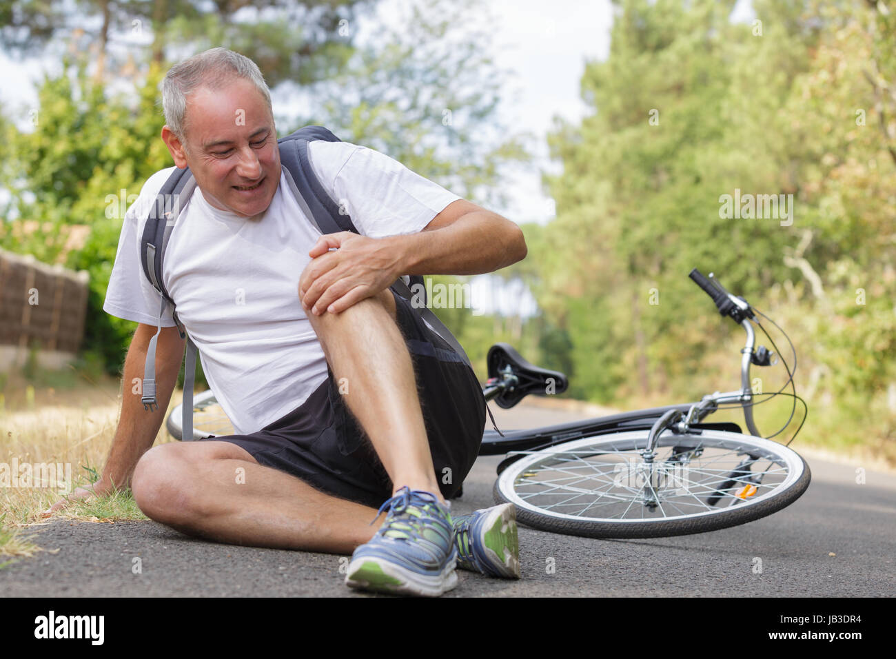 male cyclist getting injured after bicycle accident Stock Photo - Alamy
