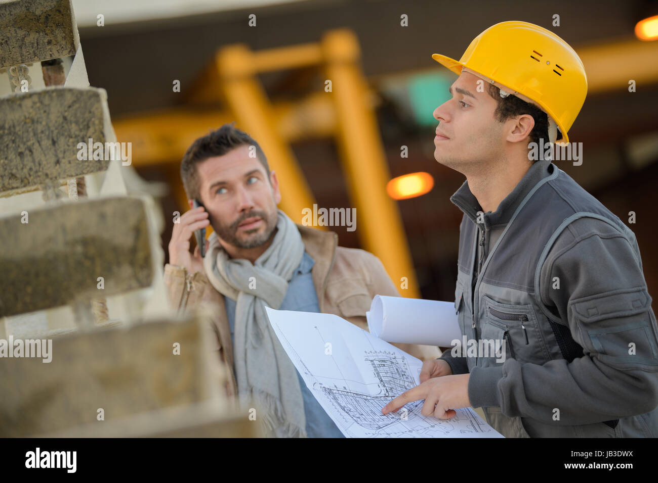 engineer and worker checking plan on construction site Stock Photo - Alamy