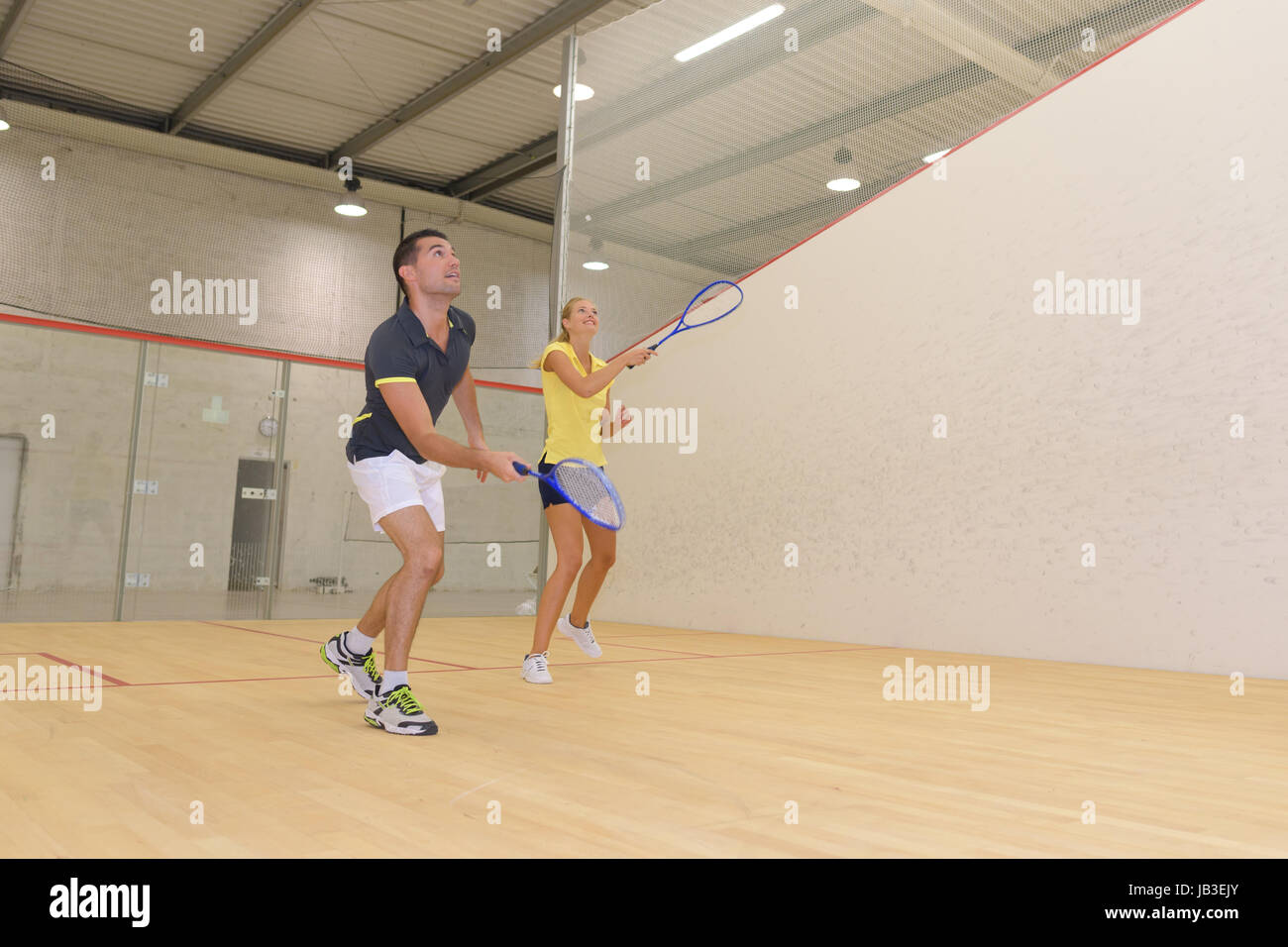 couple enjoying a game of squash in the squash court Stock Photo - Alamy