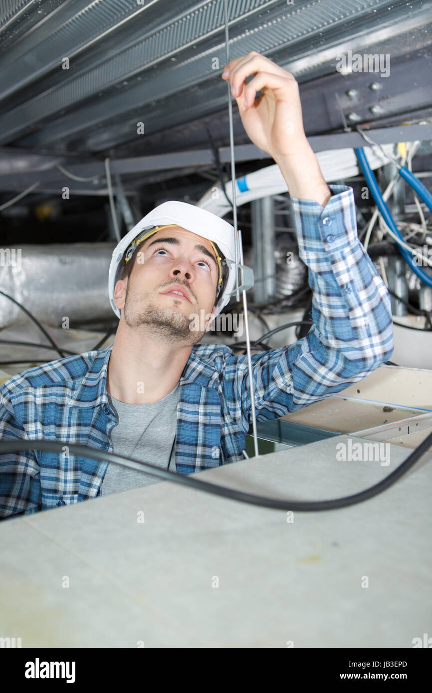 electrician wiring inside ceiling Stock Photo - Alamy