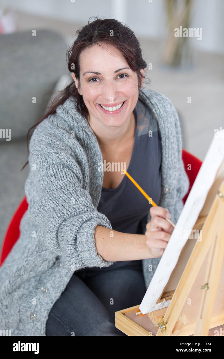 female artist working on painting in bright daylight studio Stock Photo ...