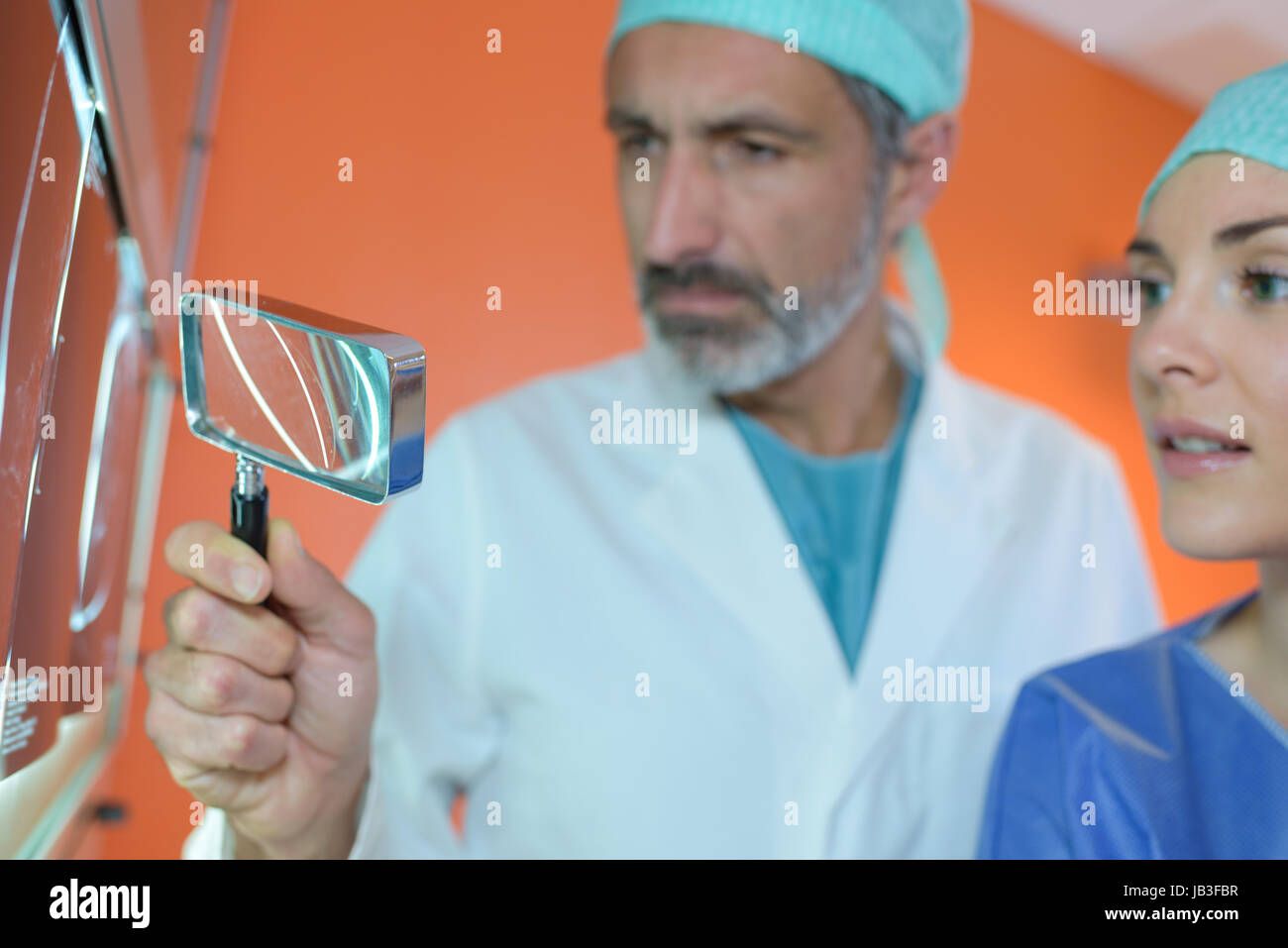 male doctor and nurse looking through magnifying glass Stock Photo - Alamy