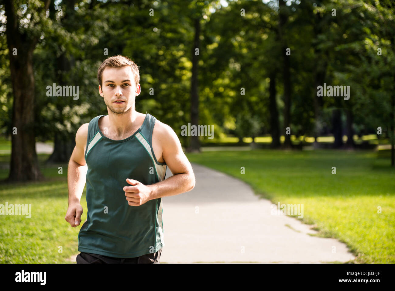 Jogging lifestyle - young attractive man running in park Stock Photo ...