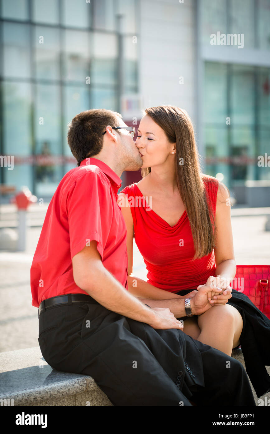 Lifestyle photo of young kissing business people outdoor in street ...