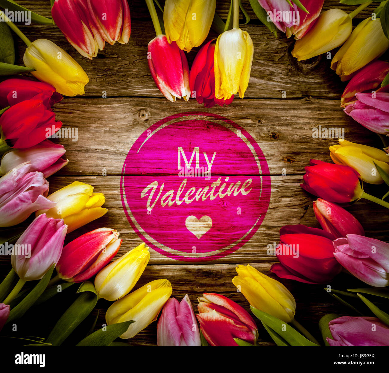 Romantic heart-shaped colourful tulip frame made of fresh flowers on a ...