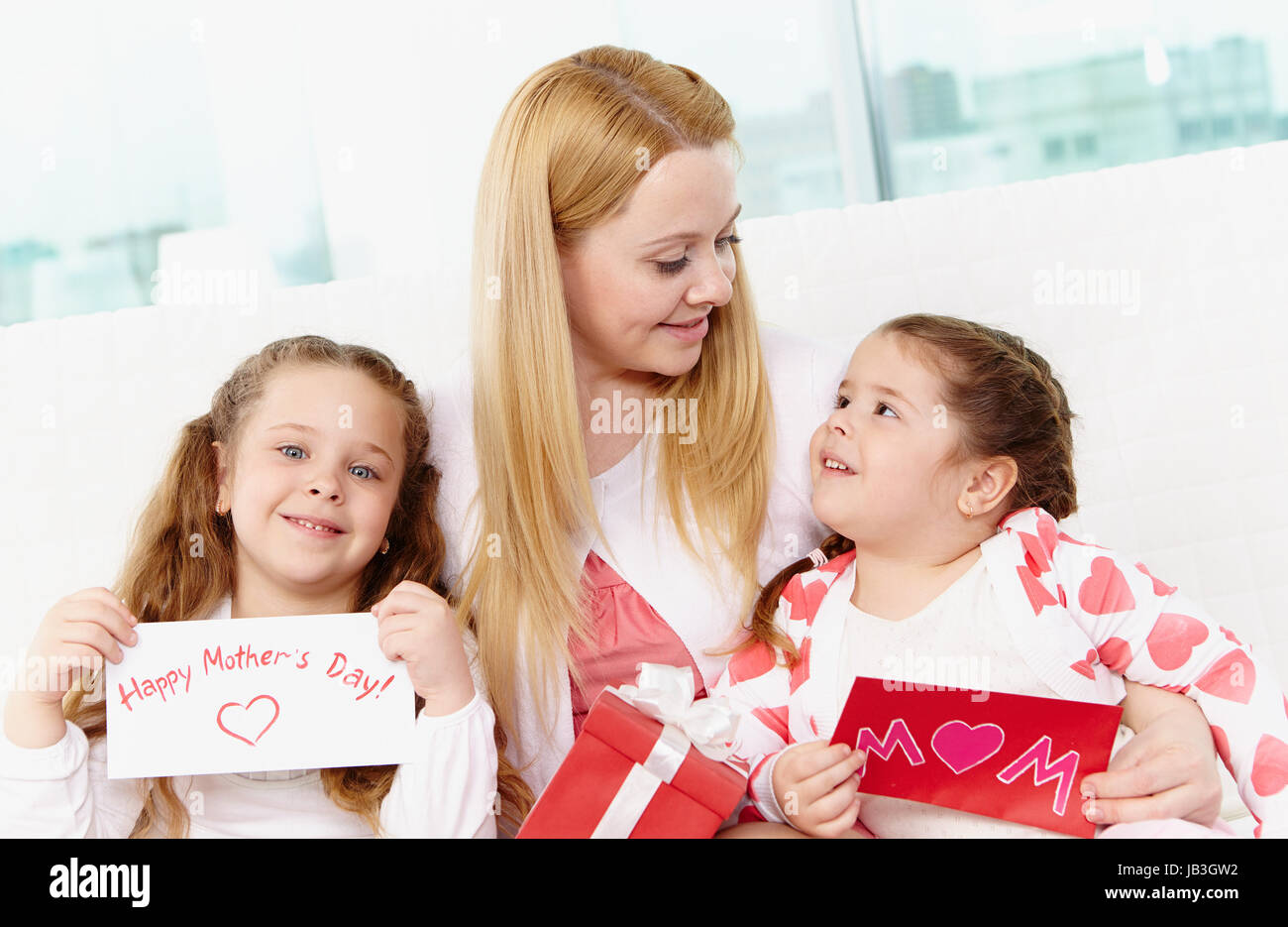 Loving mother with her two pretty daughters interacting at home Stock ...