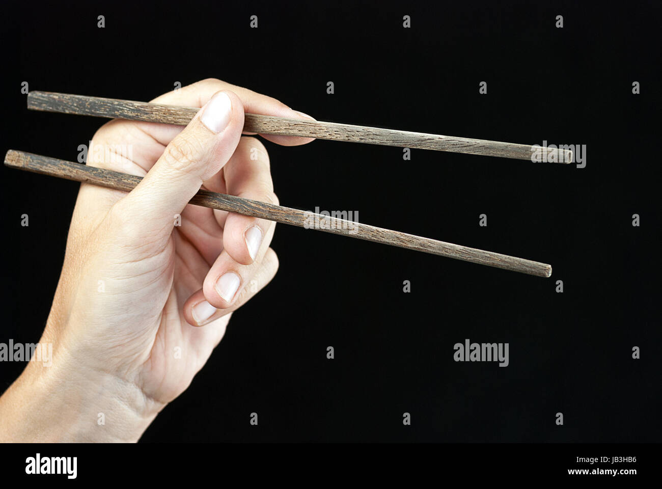 Close-up of a hand holding open chopsticks Stock Photo - Alamy