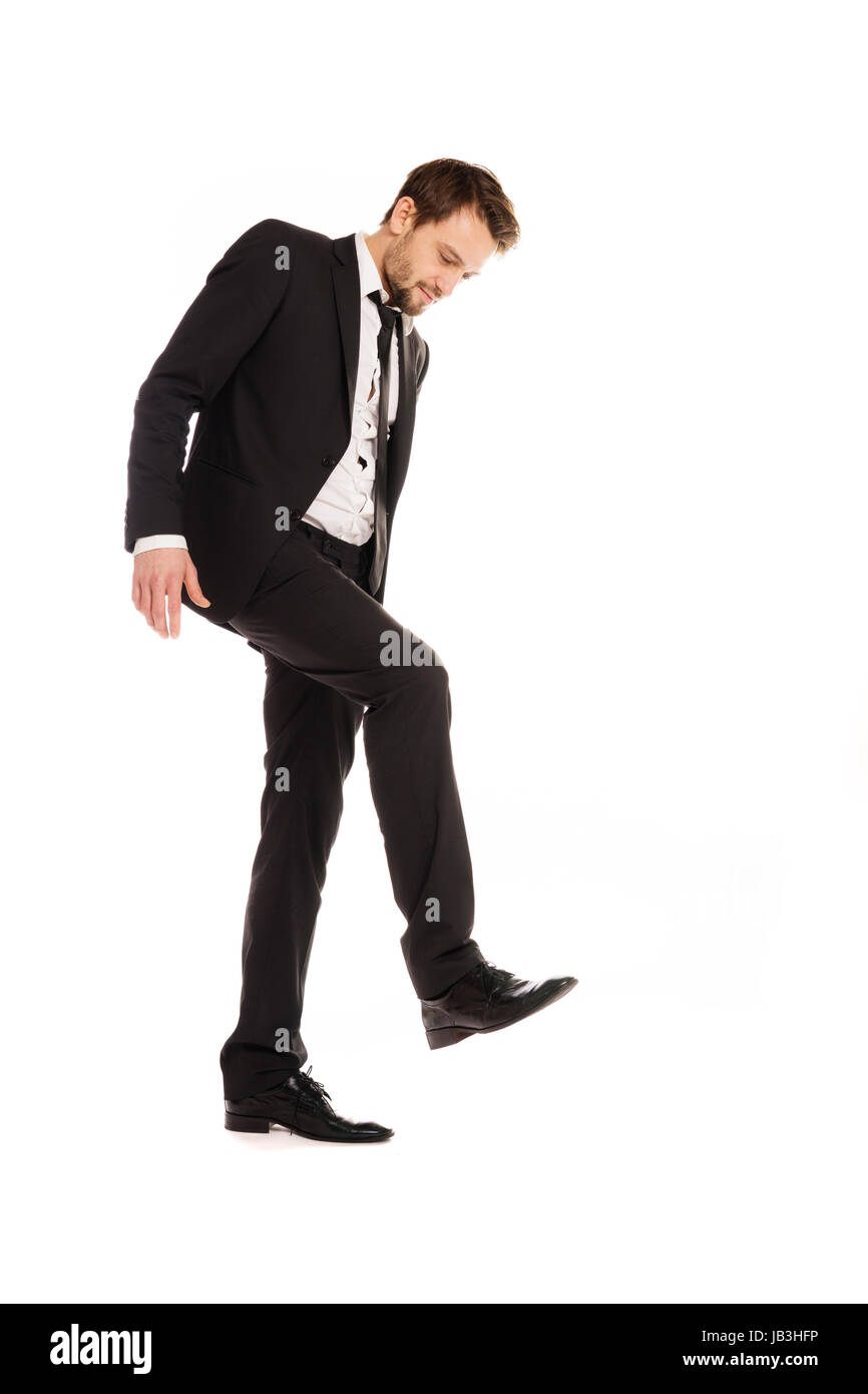 Handsome young businessman in a suit making a stamping gesture with his ...