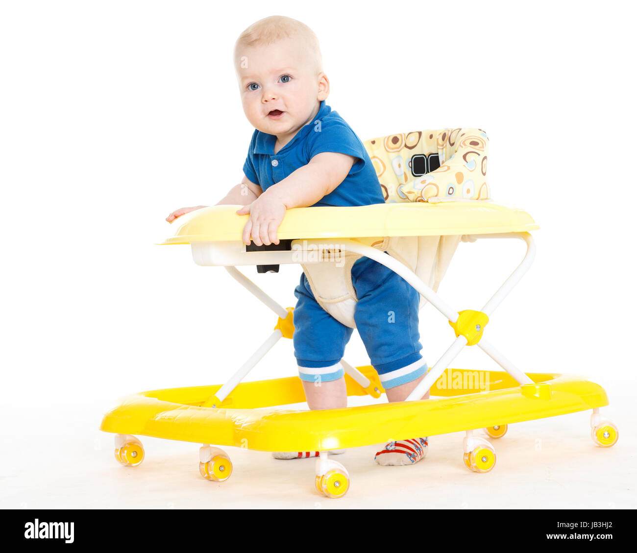 The small child learns to walk by means of Baby walker on a white ...