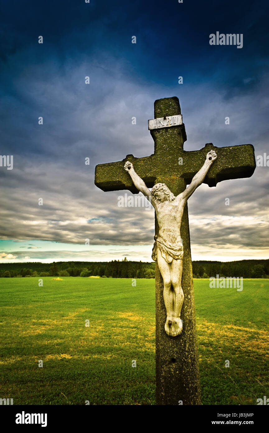 Summer evening in green and grassy fields with cross Stock Photo - Alamy