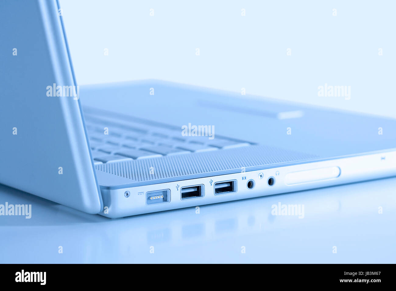 open thin silver laptop computer on white - side view, blue tone Stock ...