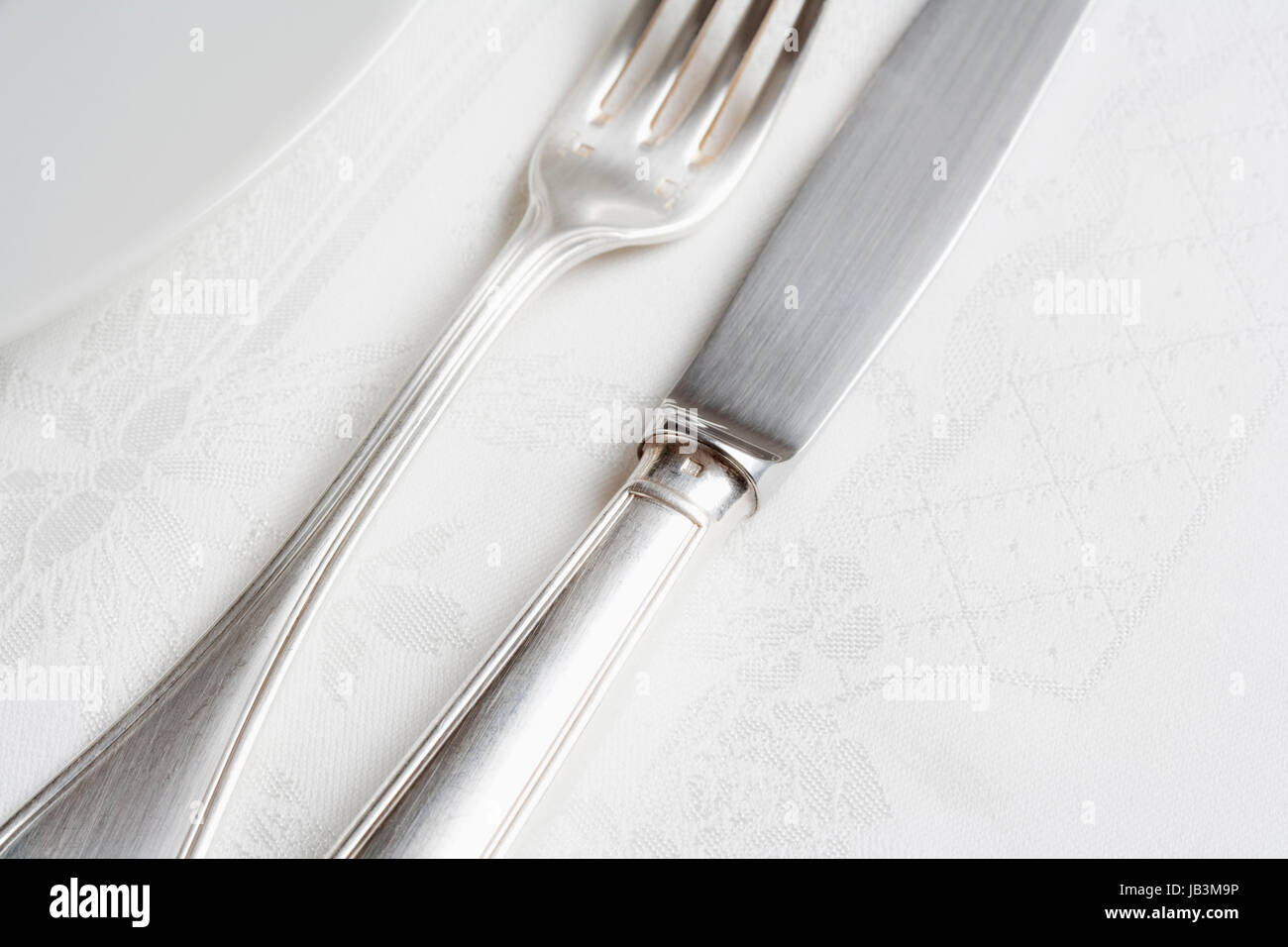 elegant table setting with silverware on white cloth Stock Photo - Alamy
