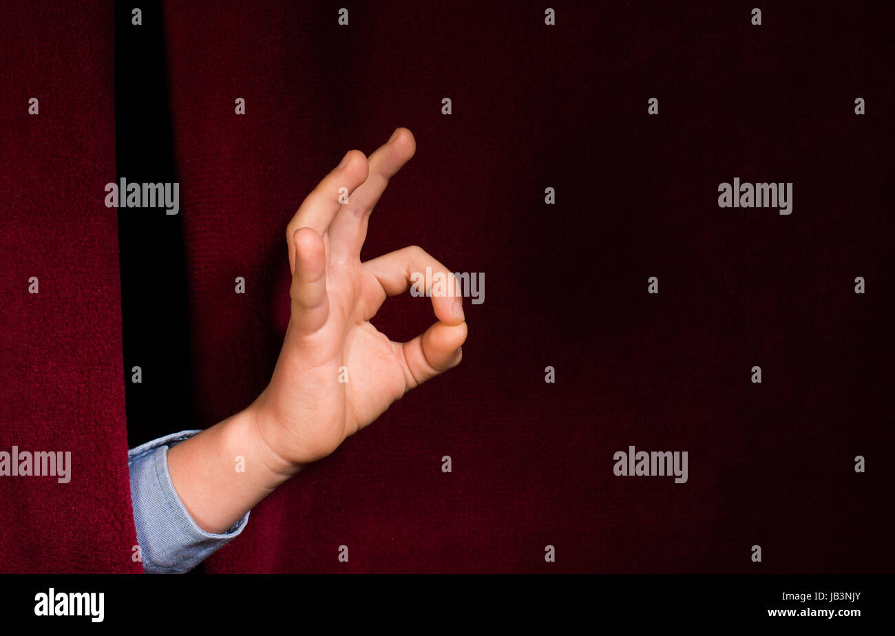 Hand symbol of success. Red curtain background Stock Photo - Alamy