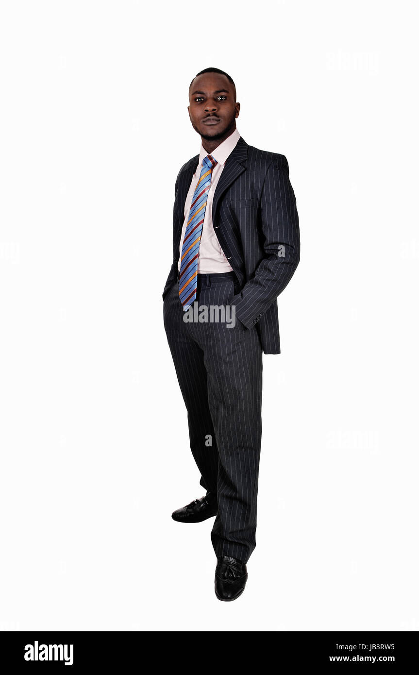 A young black business man standing in a suit and tie with his hands in ...
