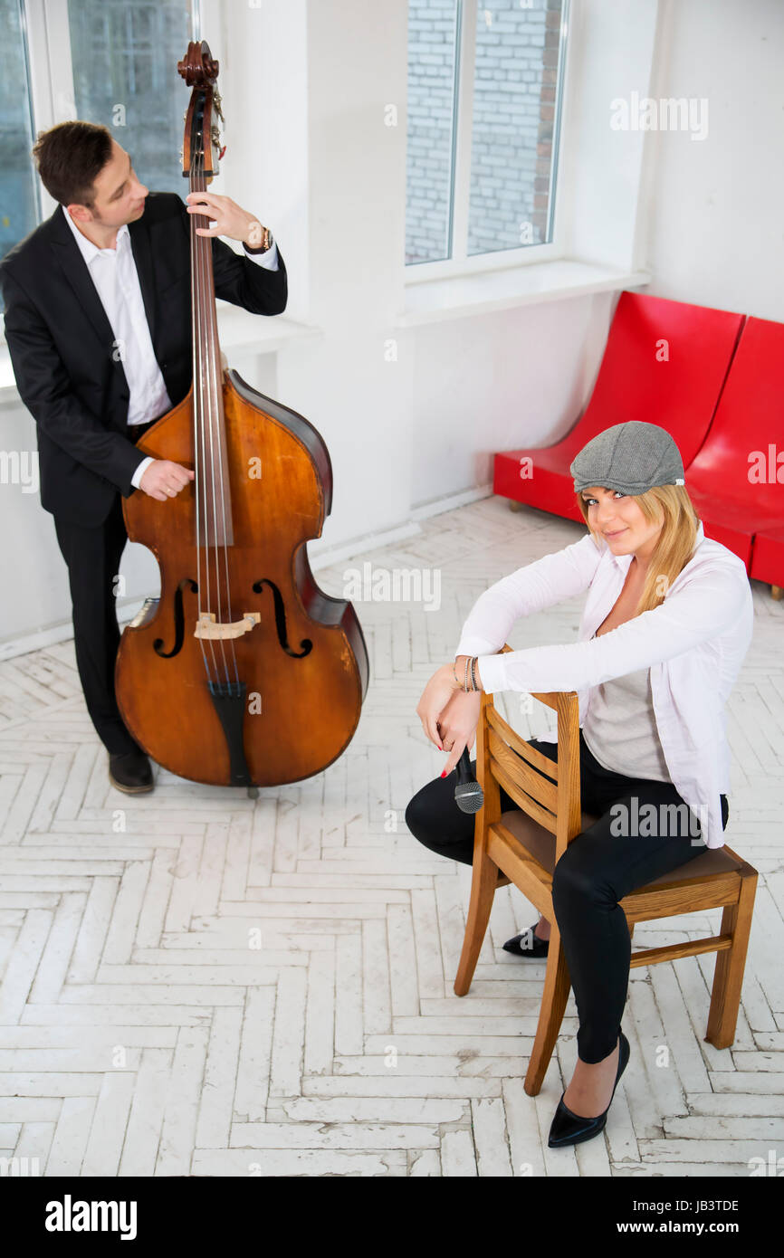 Woman sit backwards on chair and man play Stock Photo - Alamy