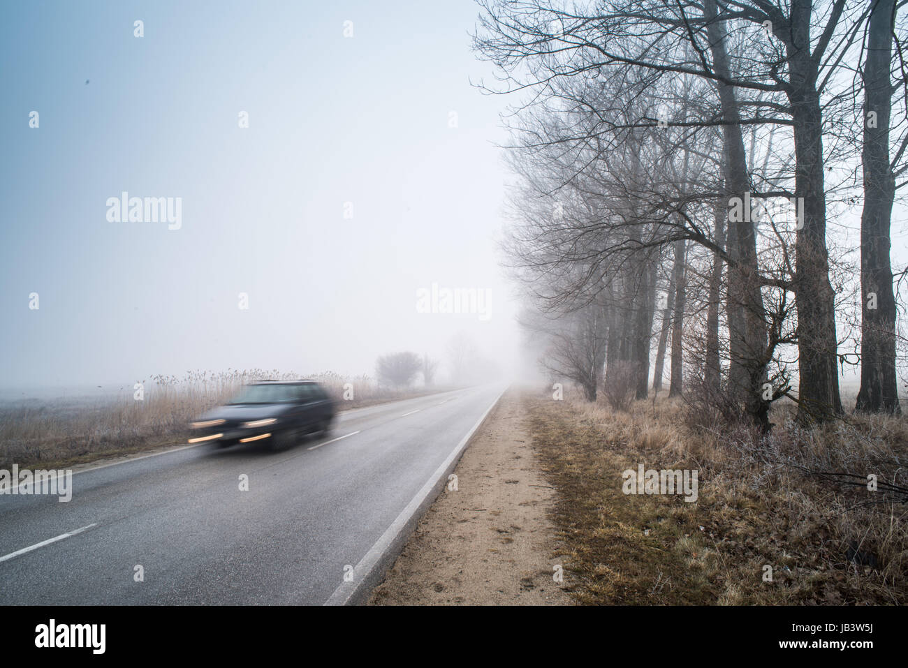 Car on a road in fog. Morning in fog Stock Photo - Alamy