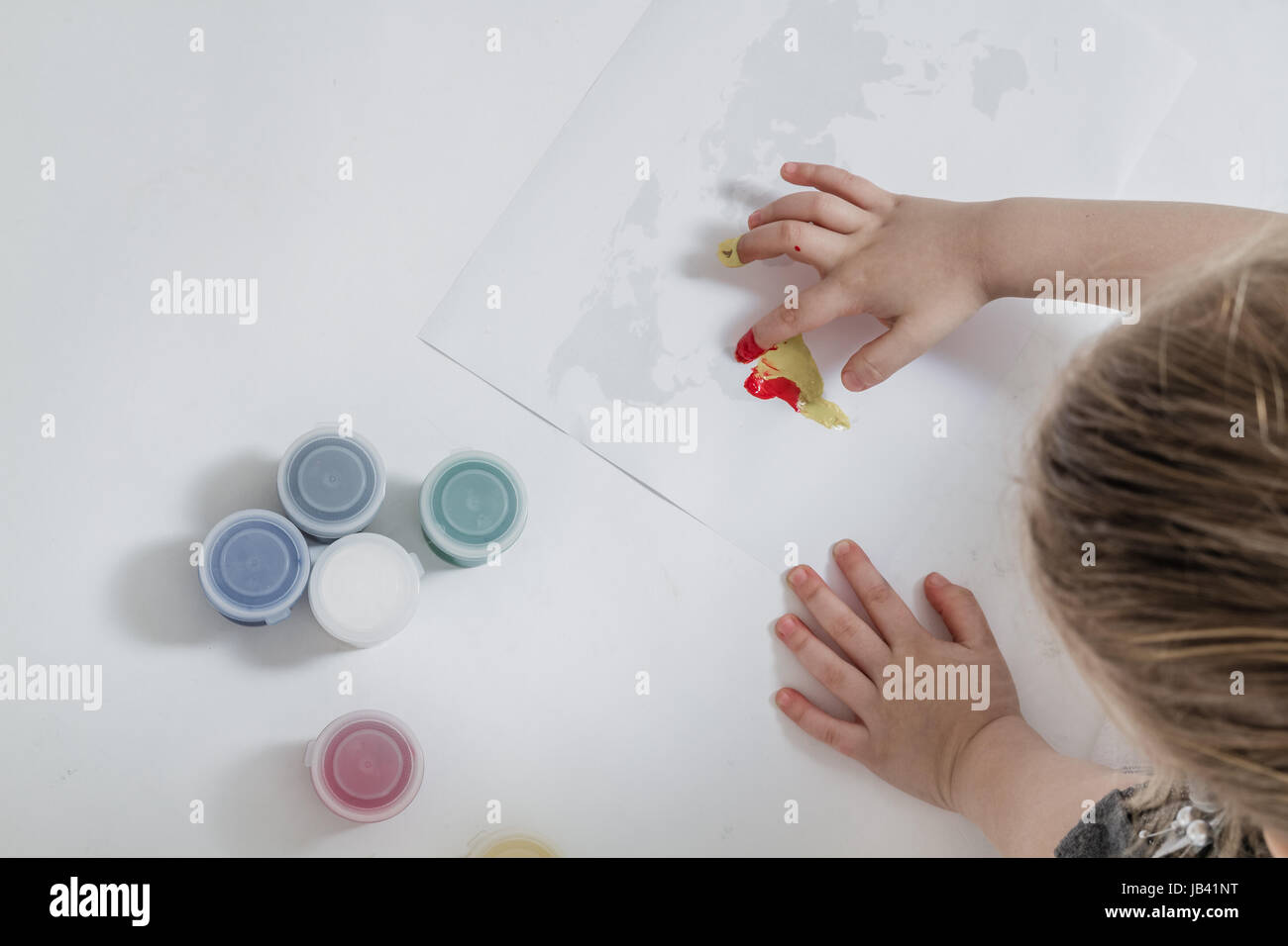 Little cute girl painting the world map with finger paint Stock Photo ...