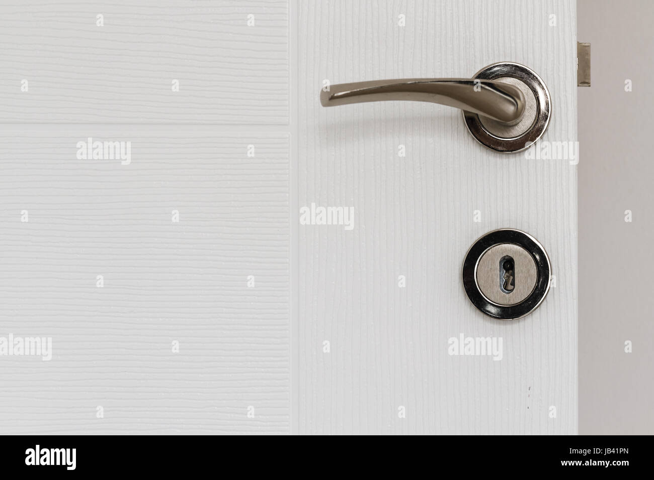 View of a door handle of a closed white door Stock Photo - Alamy