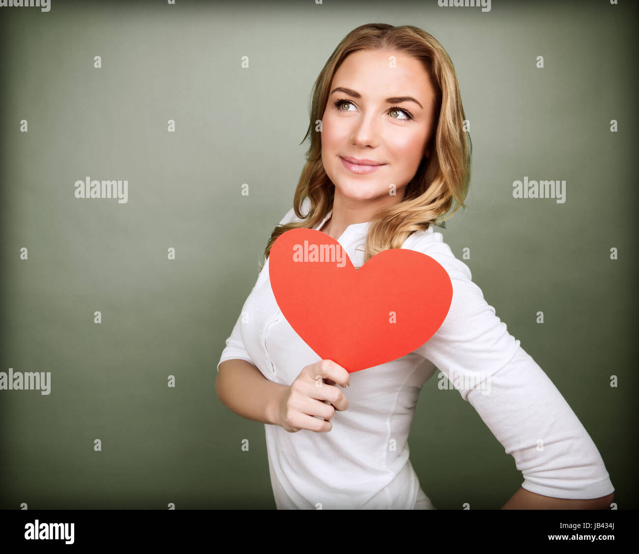 Romantic woman showing red paper heart, symbol of romantic feelings ...