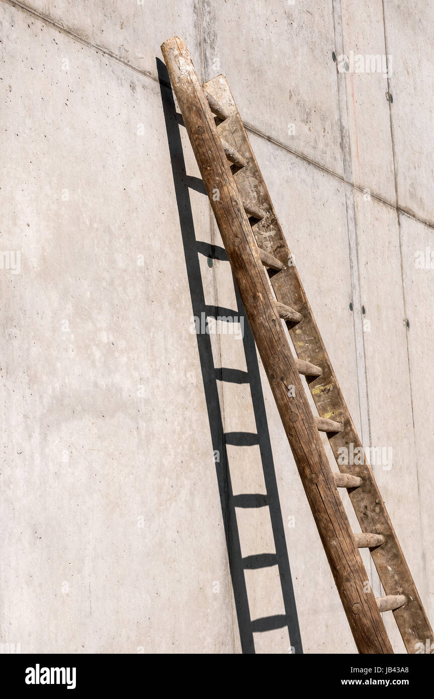 wooden ladder to the concrete wall Stock Photo - Alamy