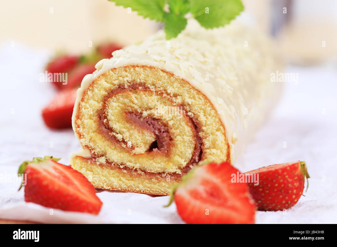 Swiss roll glazed with white chocolate icing Stock Photo - Alamy