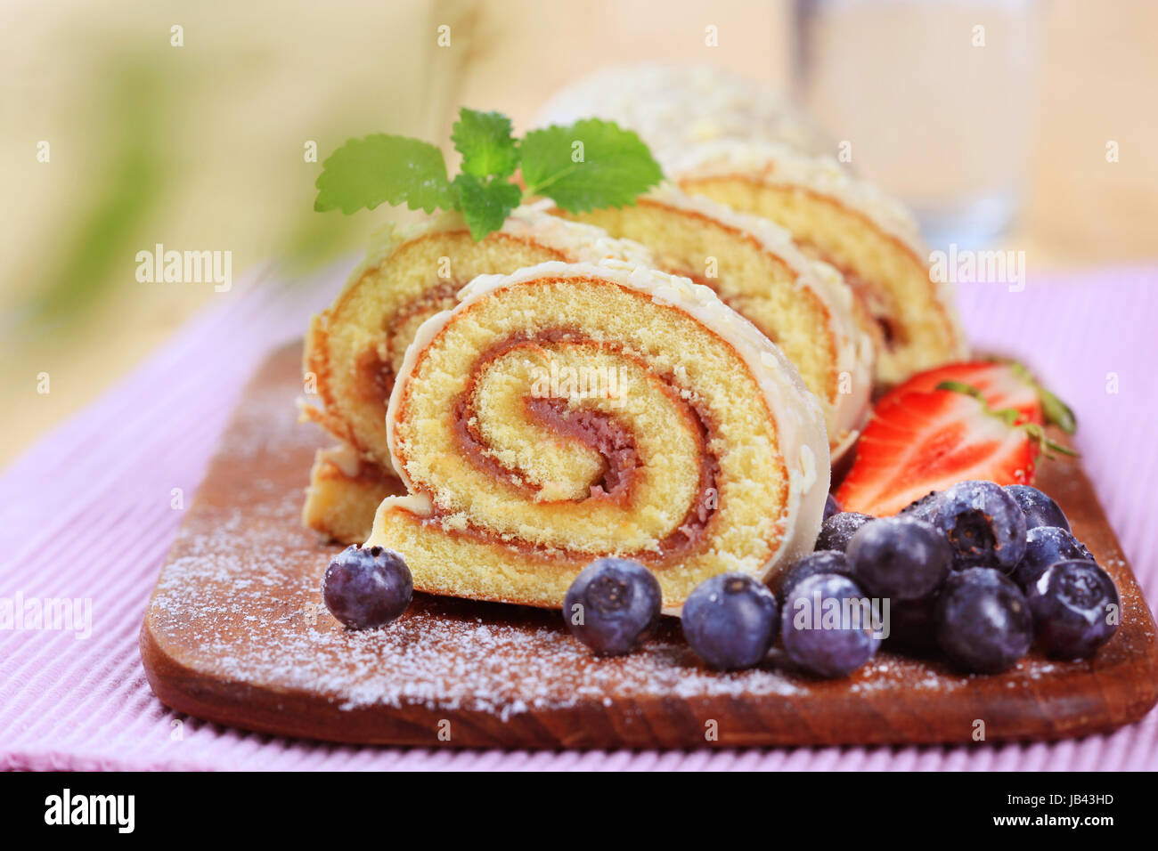 Swiss roll glazed with white chocolate icing Stock Photo - Alamy