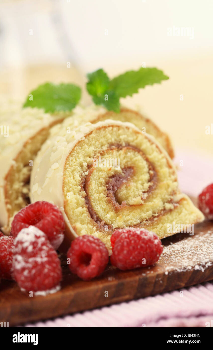 Swiss roll glazed with white chocolate icing Stock Photo - Alamy