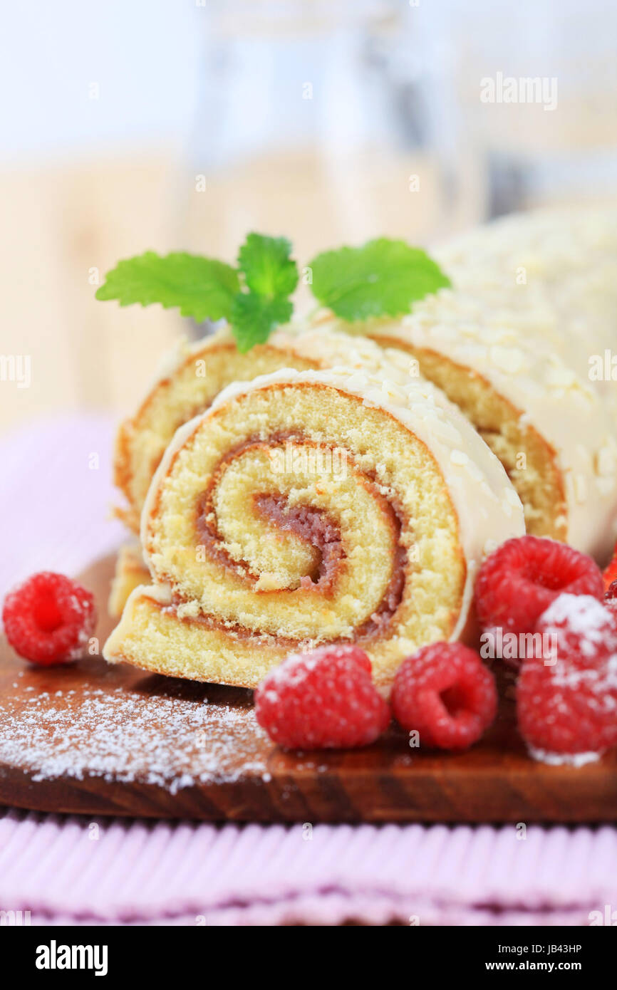 Swiss roll glazed with white chocolate icing Stock Photo - Alamy