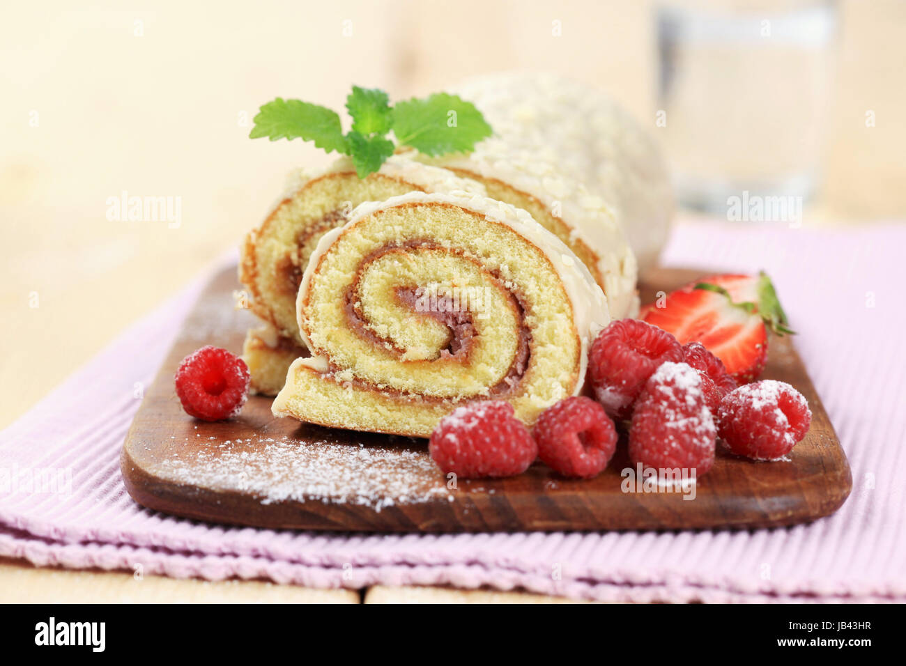 Swiss roll glazed with white chocolate icing Stock Photo - Alamy