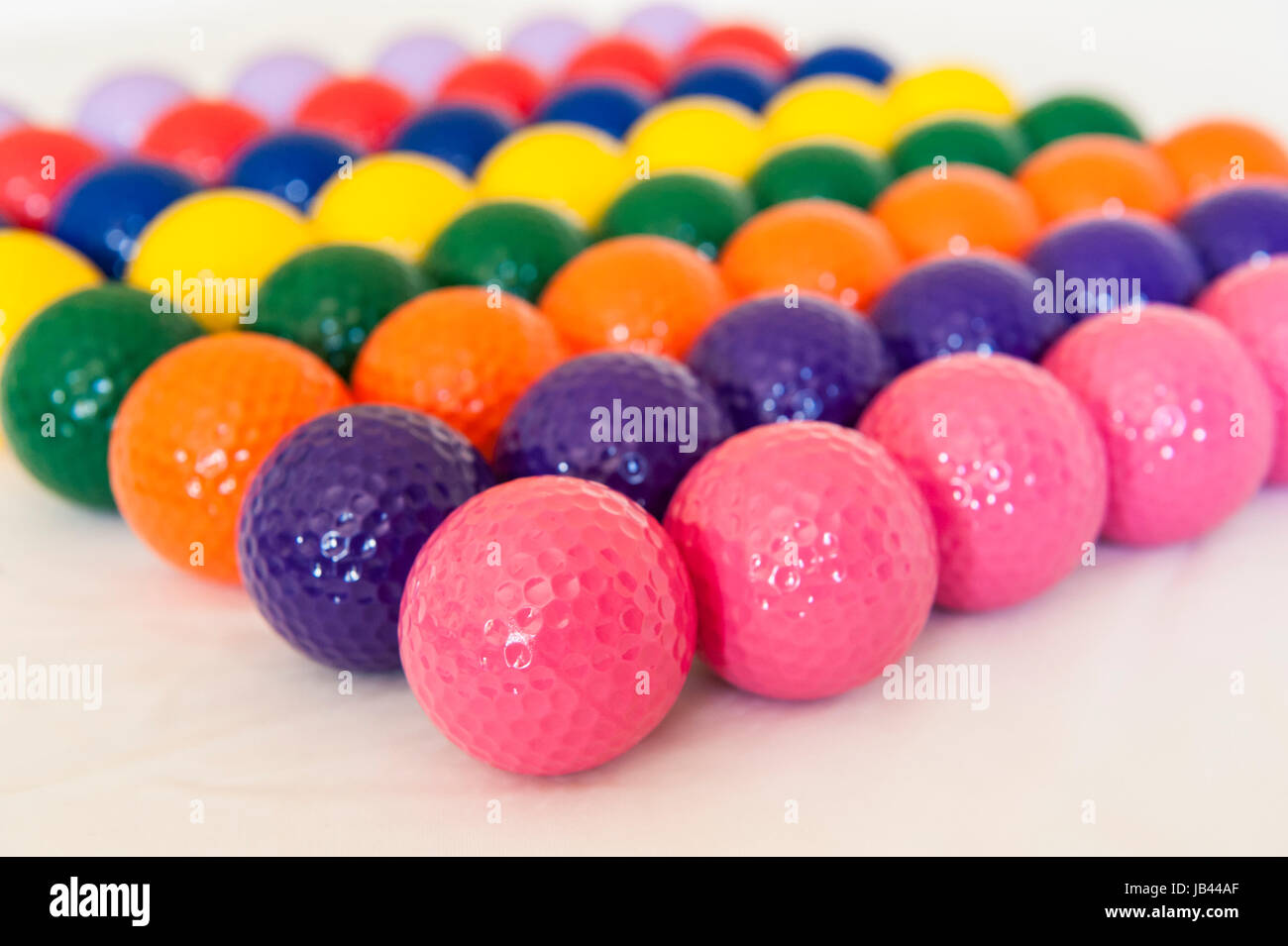 Rows of colorful mini golf balls on white background Stock Photo - Alamy