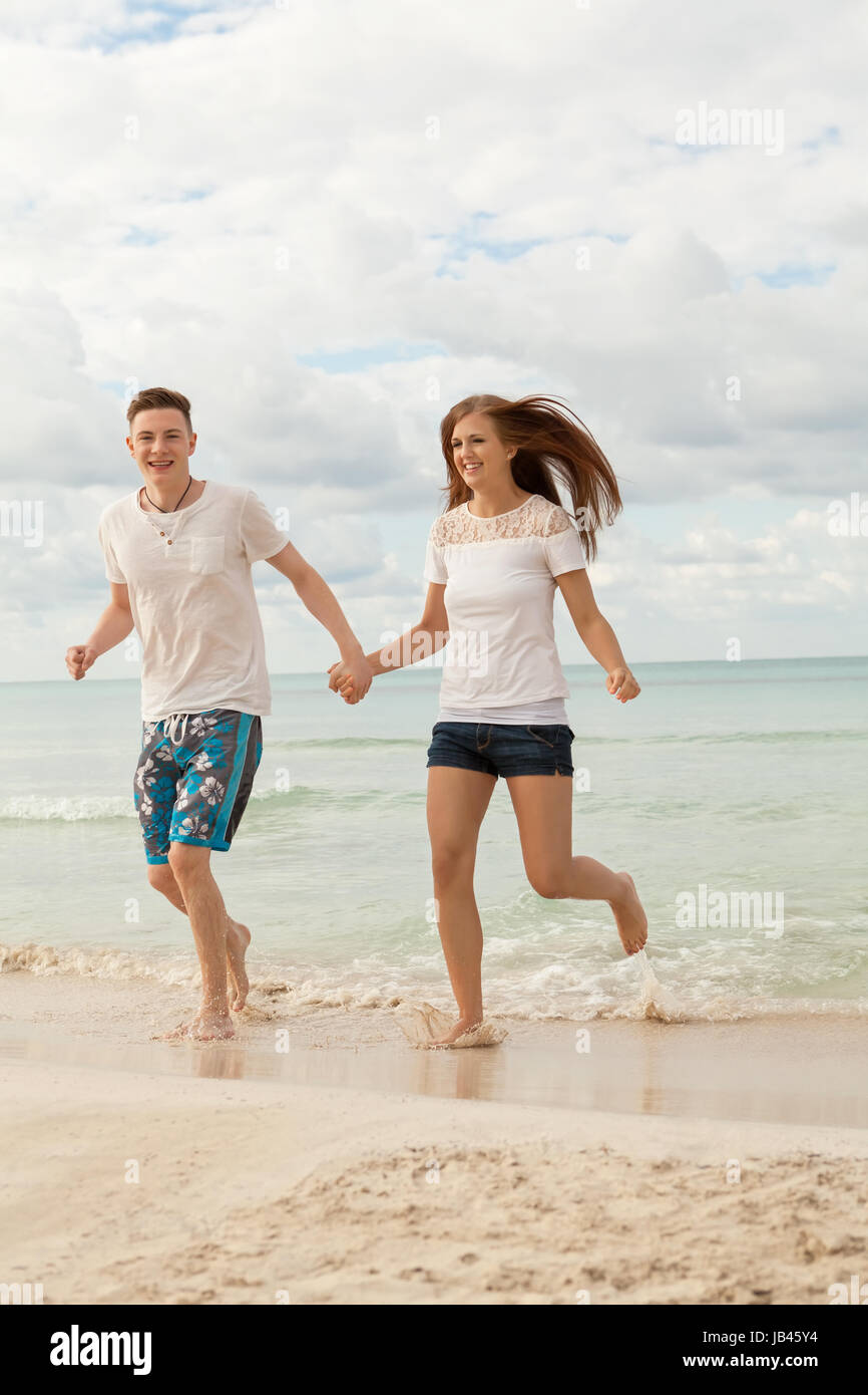lachendes junges glückliches paar im sommer am strand freizeit urlaub ...
