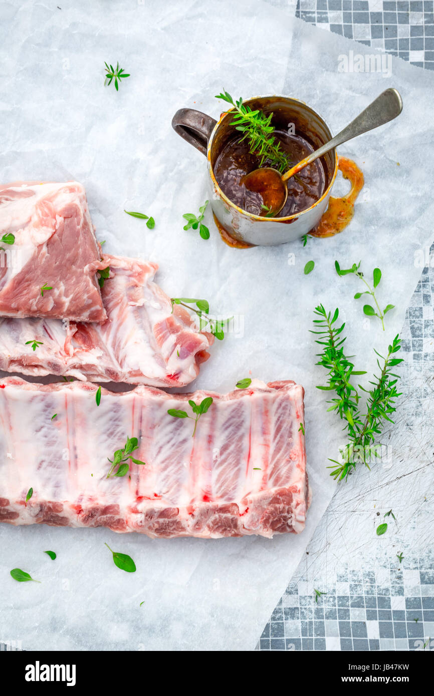 Preparing fresh ribs with marinade and herbs for grill Stock Photo - Alamy