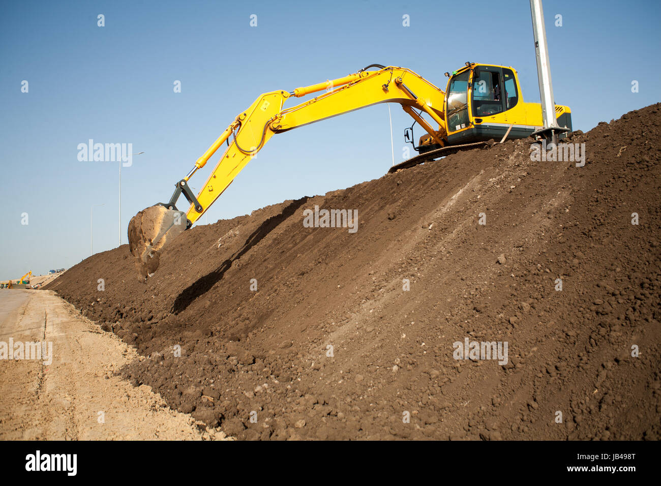 A large construction excavator of yellow color on the construction site ...