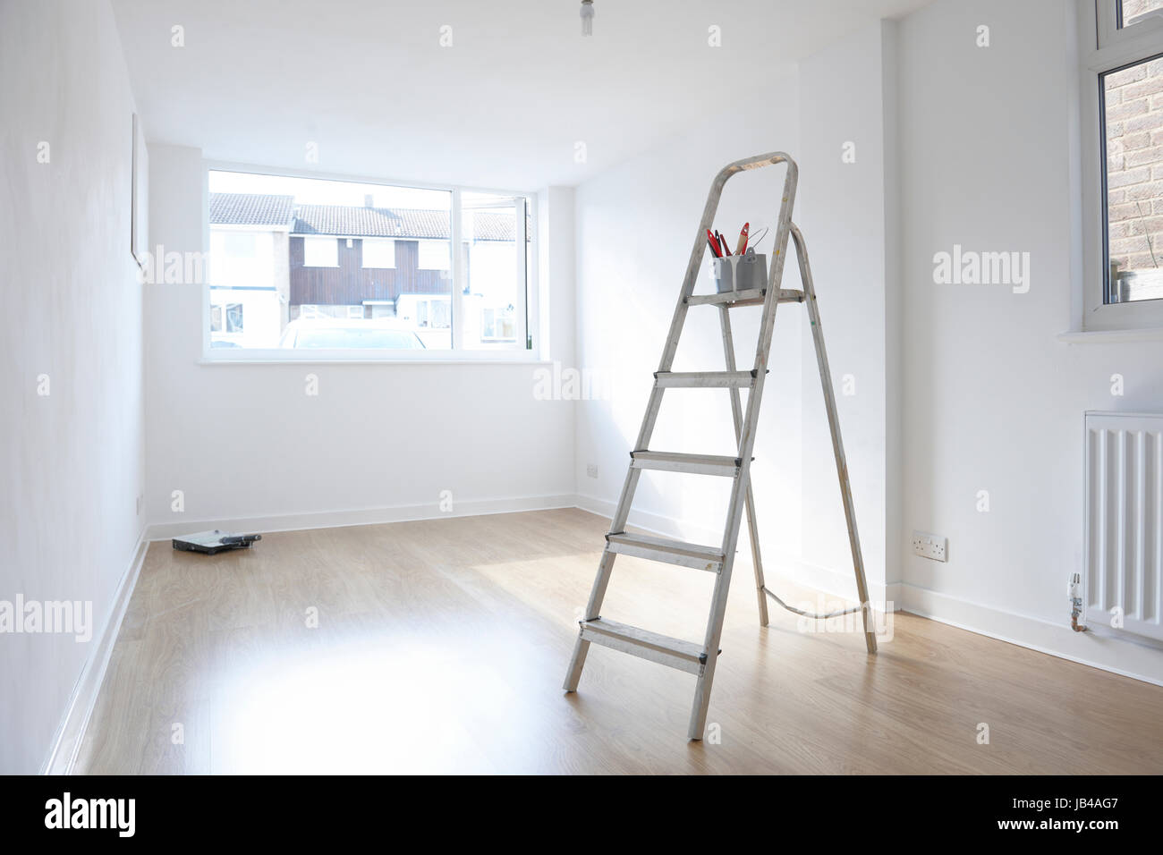 ladder with paint pot and brushes standing in empty room Stock Photo ...