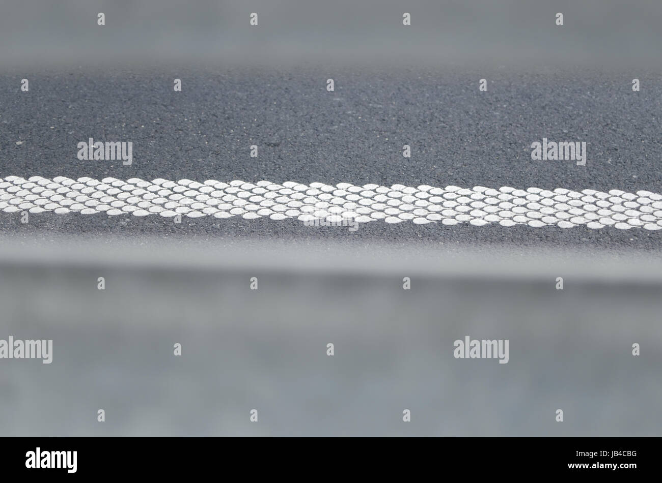 White Rumble Strip on the Road thru Crash Barriers Stock Photo - Alamy