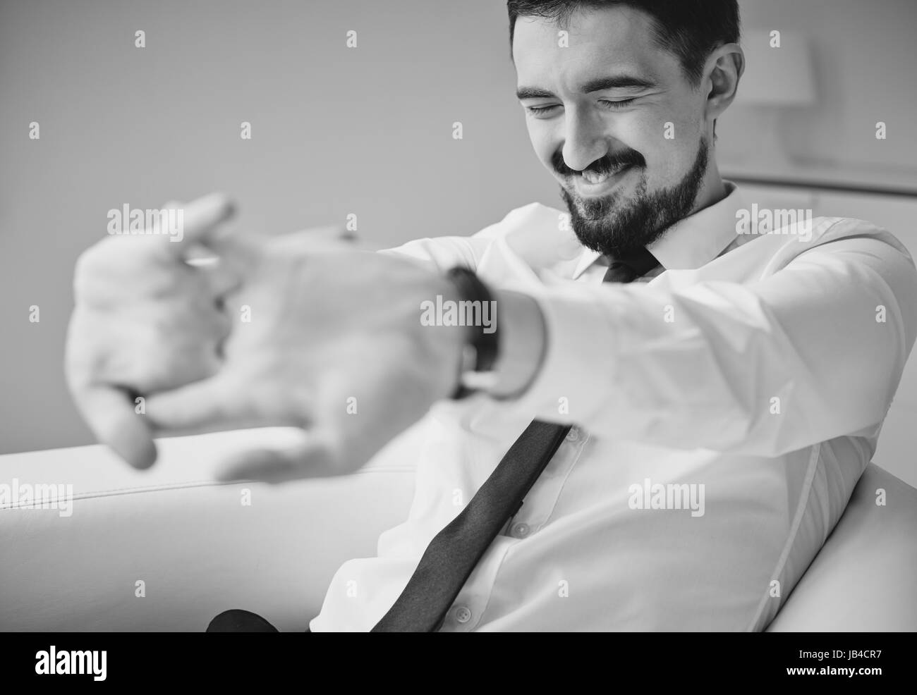 Portrait of posh guy in formalwear sitting and stretching himself Stock ...