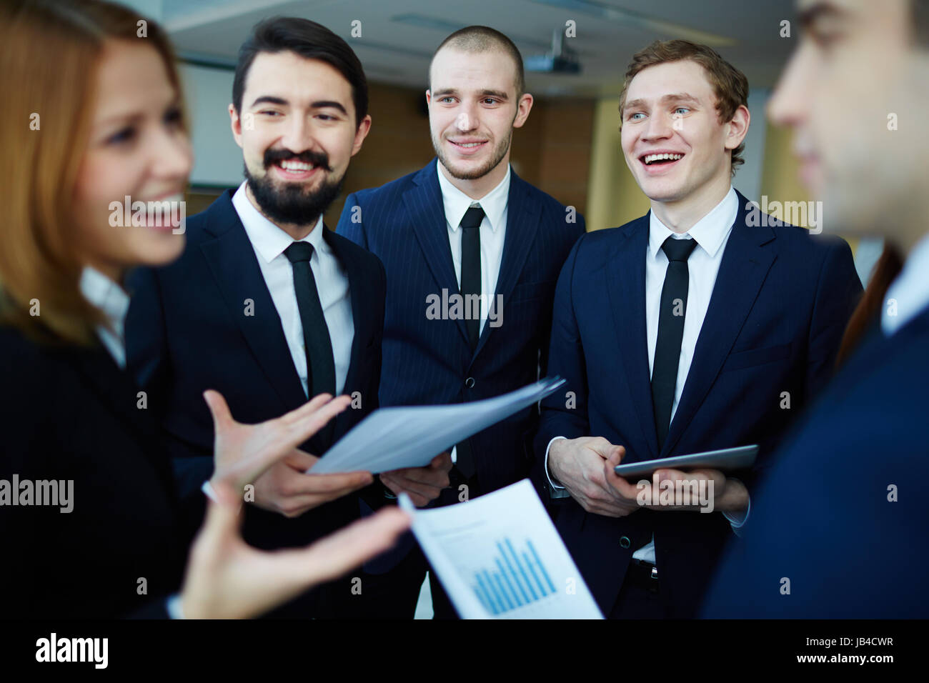 Group of business partners listening to their female co-worker ...
