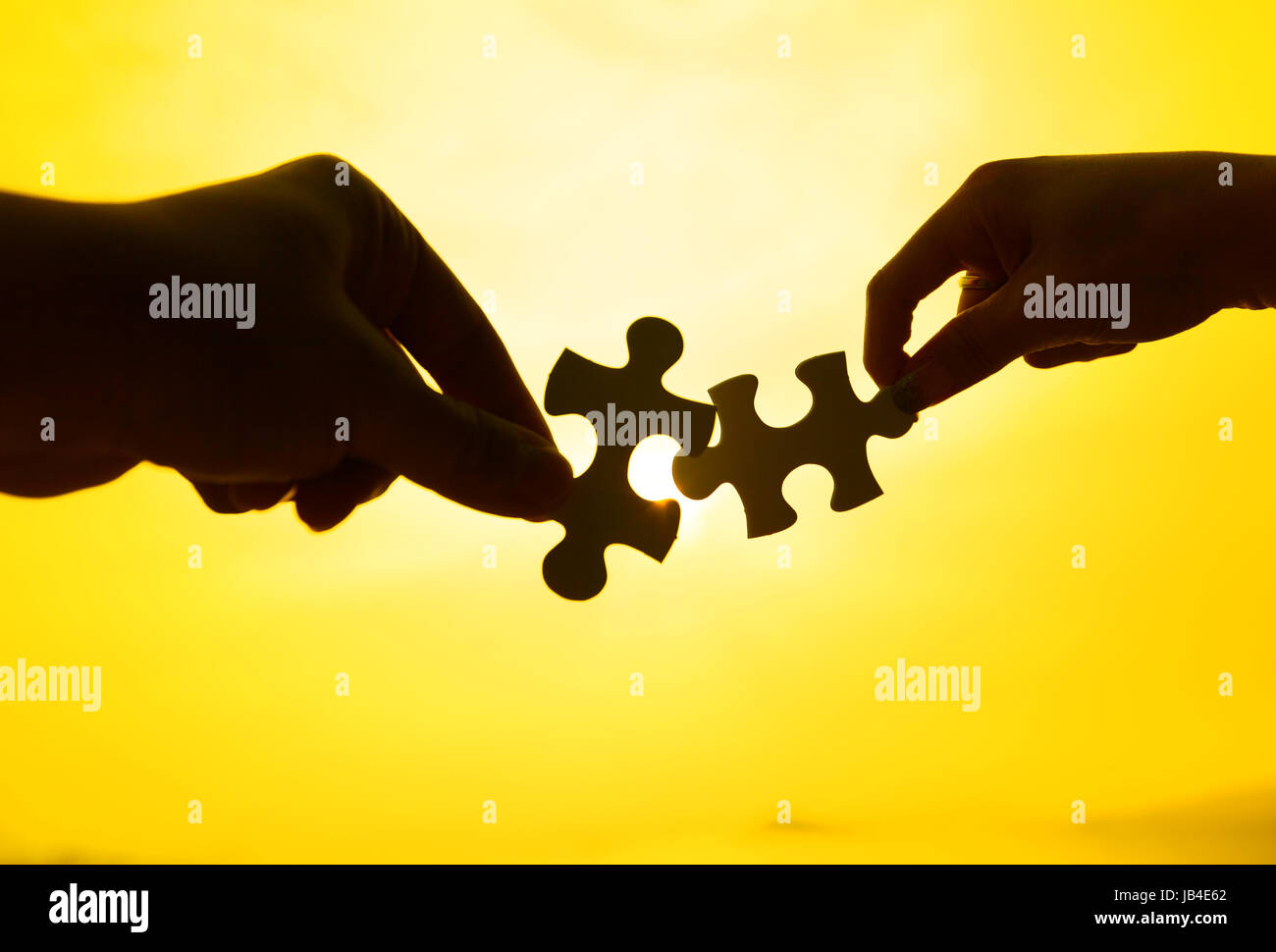 Silhouette of two hands connect puzzle together Stock Photo - Alamy