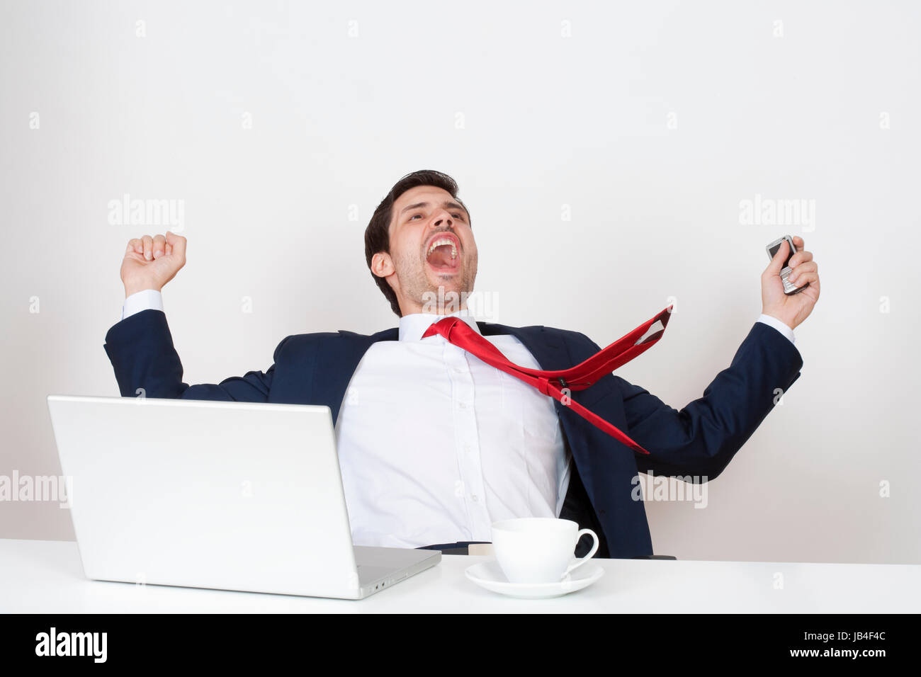 young business executive in suit cheering behind desk Stock Photo - Alamy