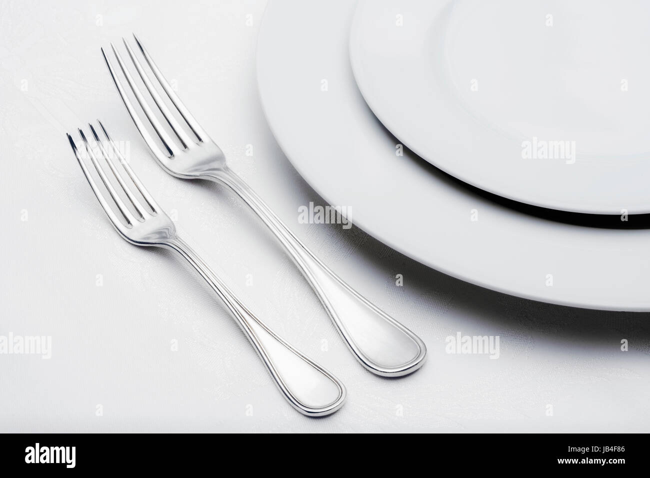 elegant table setting with silverware on white cloth Stock Photo - Alamy