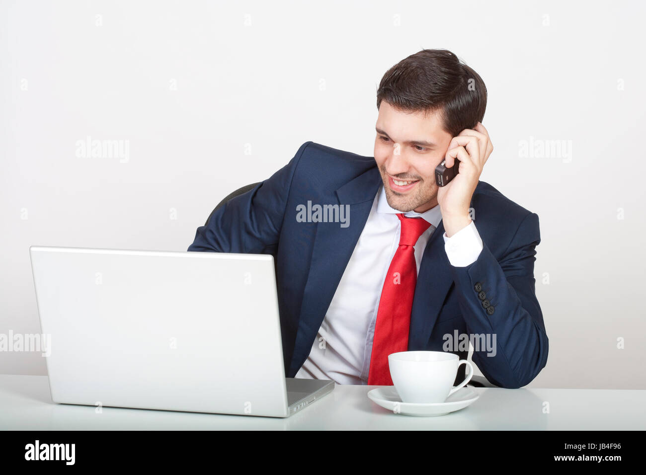young business executive in suit behind desk with laptop Stock Photo ...