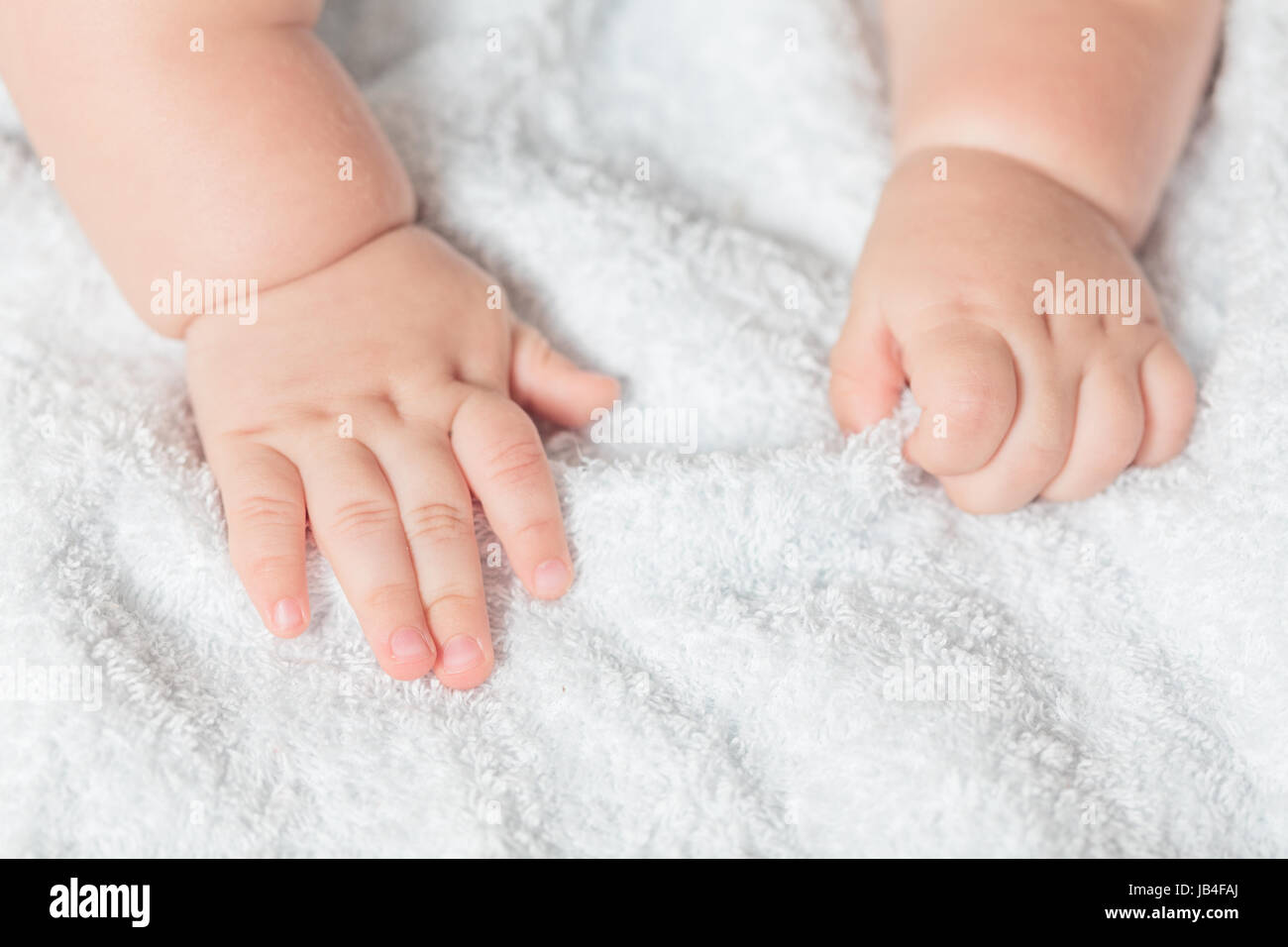 Hands of a baby on terry background Stock Photo - Alamy