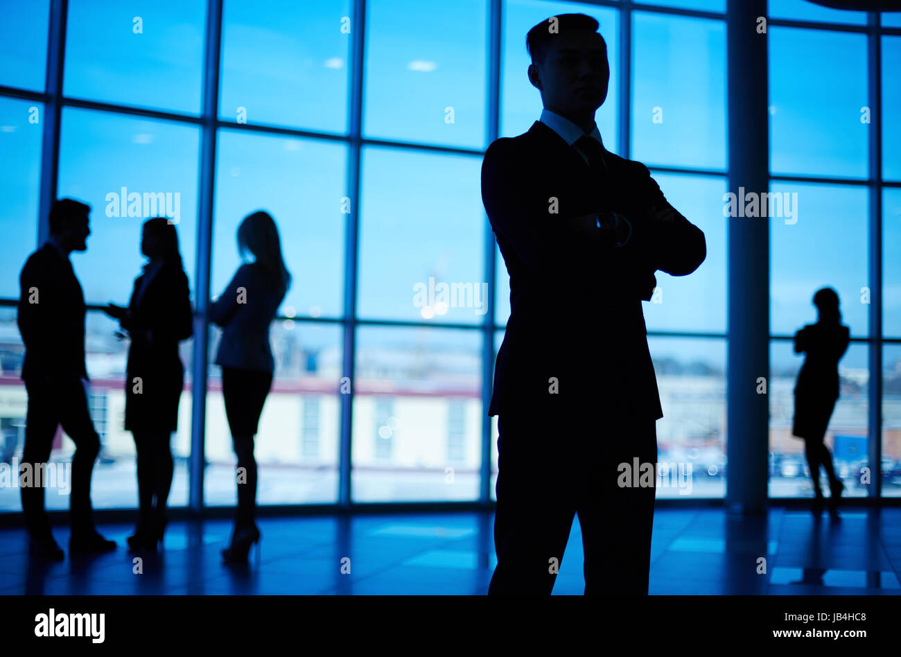 Outlines of business team standing against window with leader in front ...